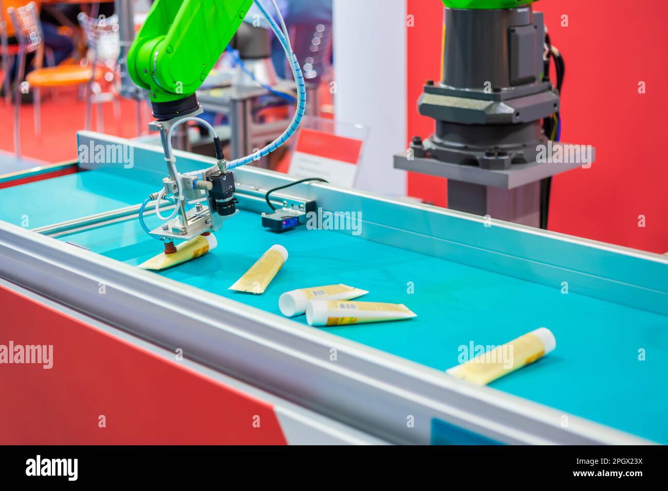 Robotic arm manipulator with suction cup moves cream tubes at trade ...