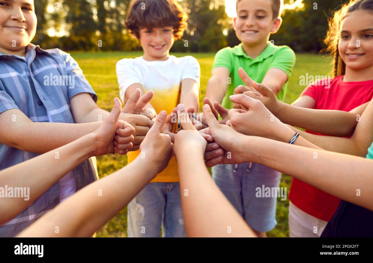 Happy children joining hands and giving thumbs up together Stock Photo ...