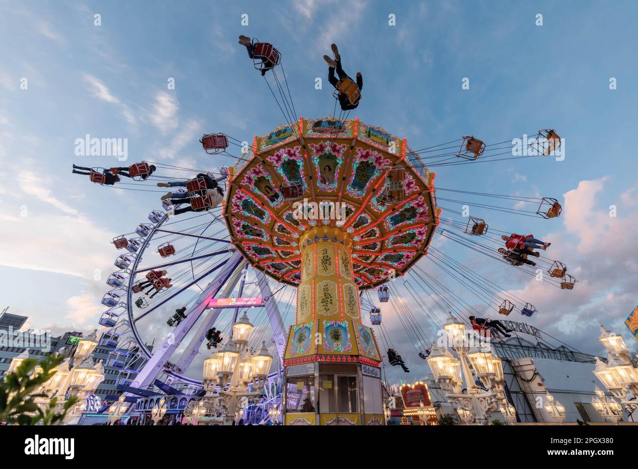 Hamburg, Germany. 24th Mar, 2023. Visitors ride a chain carousel on the ...