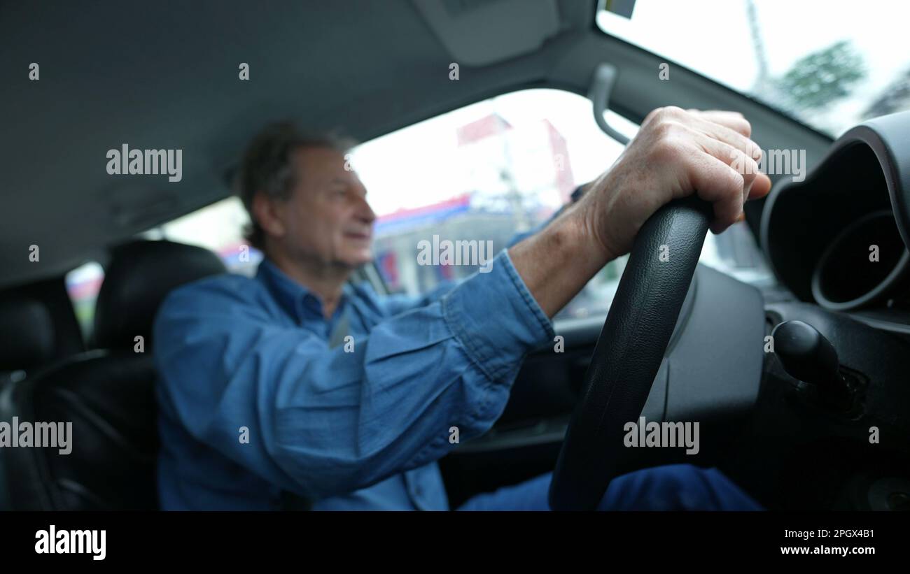 Close up hands holding steering driving in city. One senior male ...