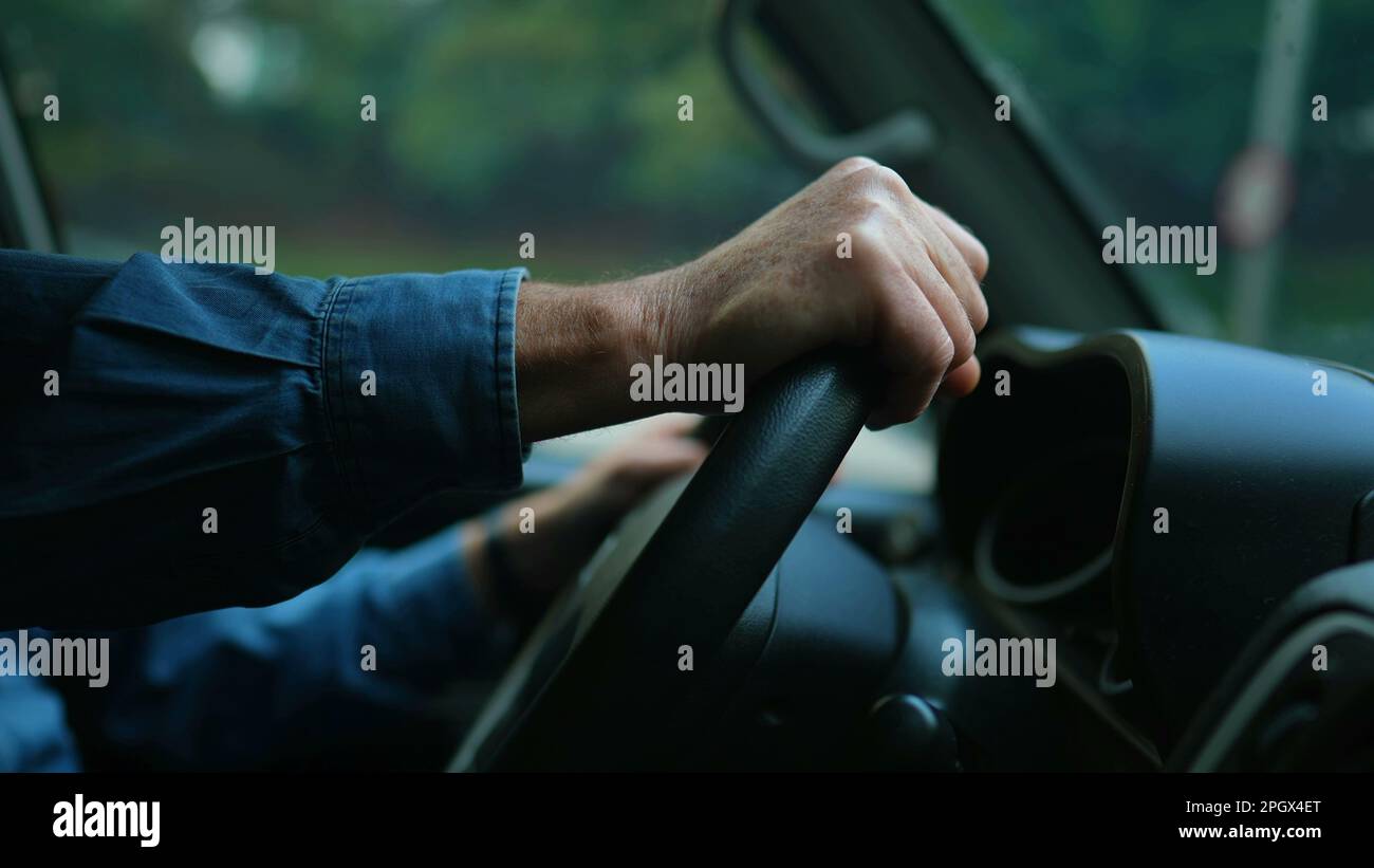 Close up hands holding steering driving in city. Driver signaling turn ...