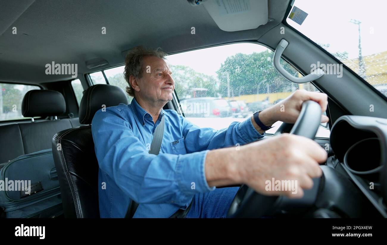 One older man driving in city in moving vehicle. Retired senior male ...