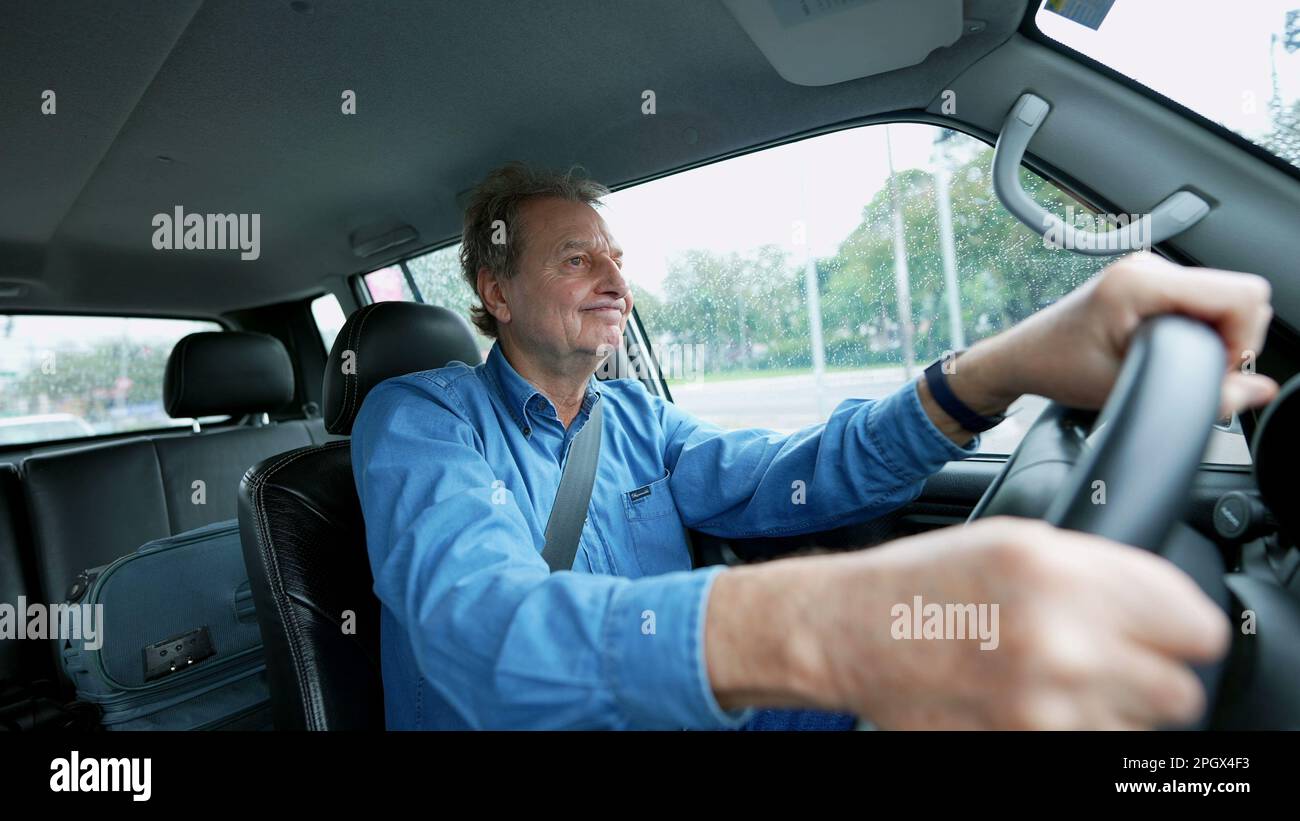 One older man driving in city in moving vehicle. Retired senior male ...