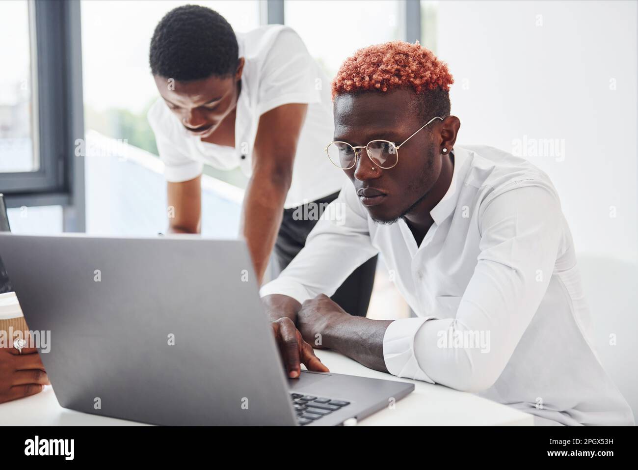 Concentrated at project by using laptop. Group of african american ...