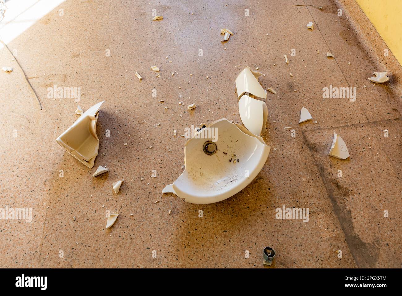 A broken old sink lying on the floor in a room of an old abandoned ...