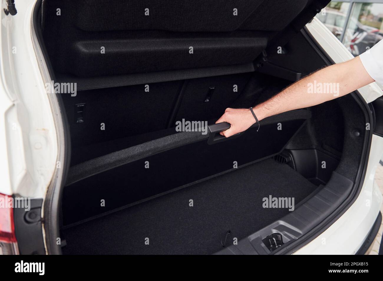 Woman's hands opening car trunk. Close up view. White modern automobile ...