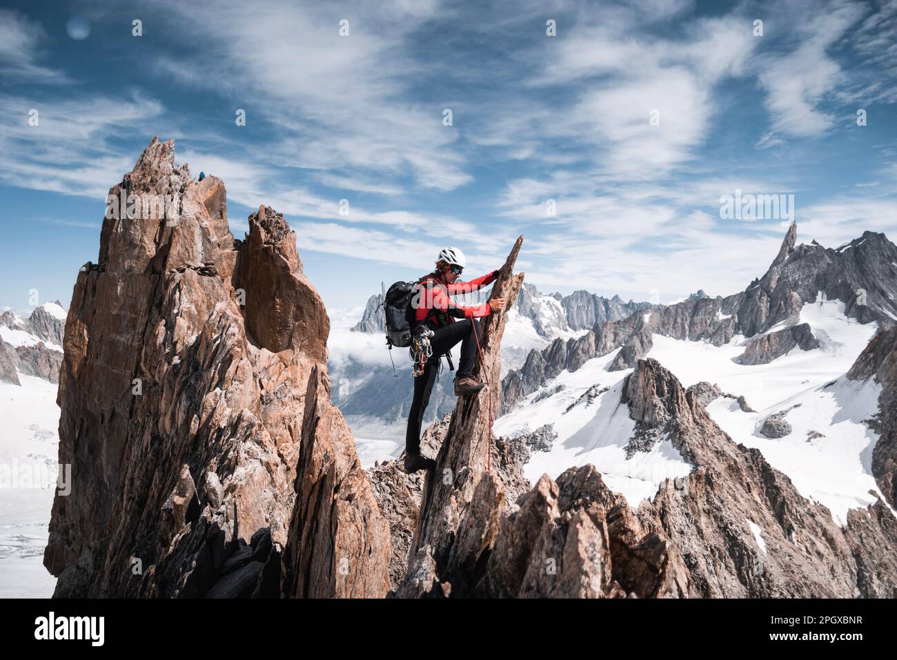 Mountaineer climbing a narrow rock ridge in the Mont Blanc massif in ...