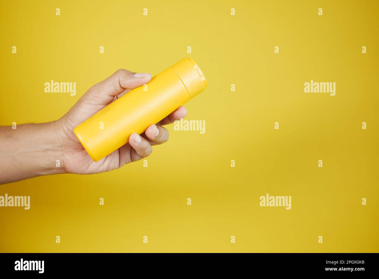 hand holding a sunscreen cream container Stock Photo - Alamy