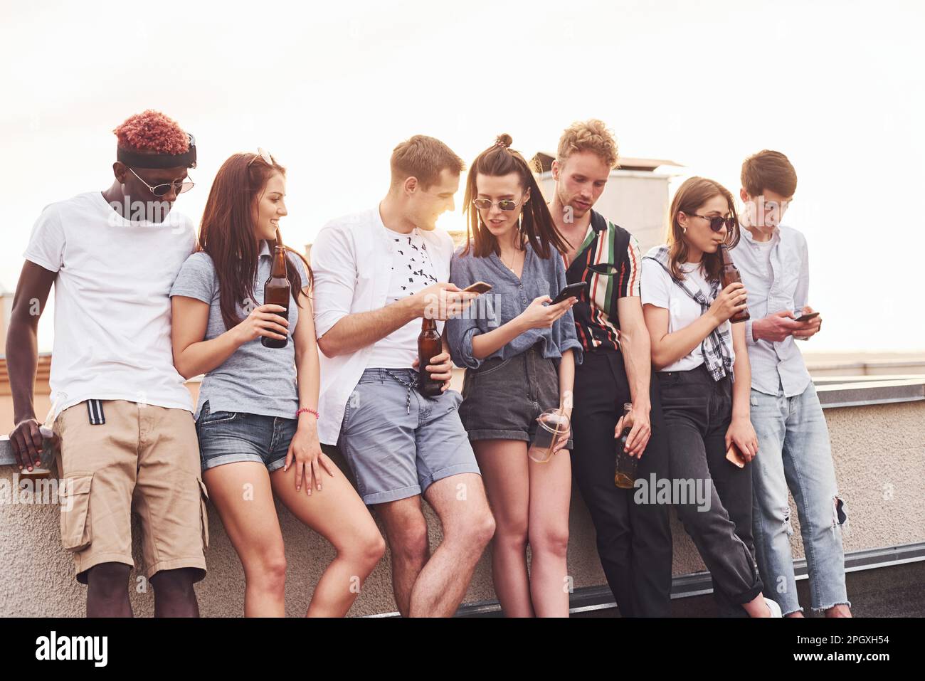 Cloudy weather. Group of young people in casual clothes have a party at ...