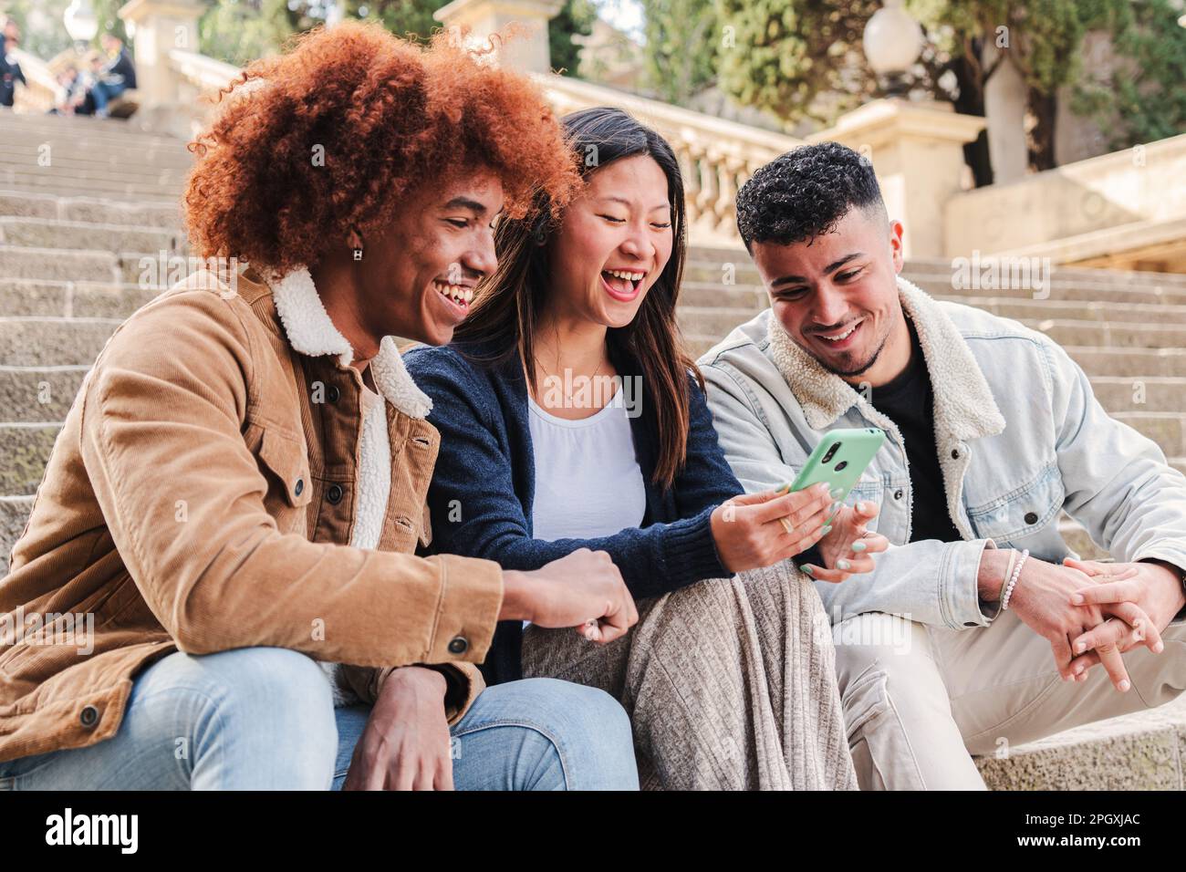 Three teenagers sitting together using hi-res stock photography and ...