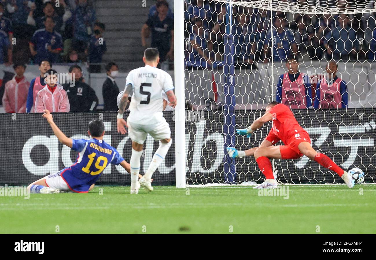 Tokyo, Japan. 24th Mar, 2023. Japan's Takuma Nishimura (L) scores a ...
