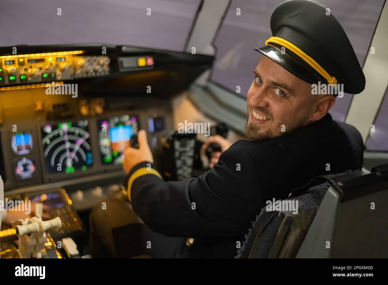 Caucasian bearded man smiling while sitting in a flight simulator ...
