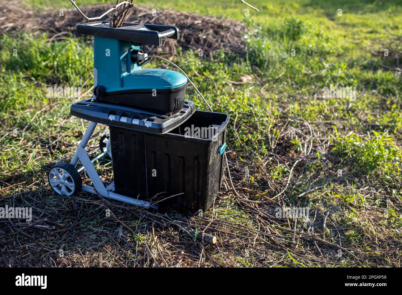shredded branches and vines in a container electric garden grinder to ...
