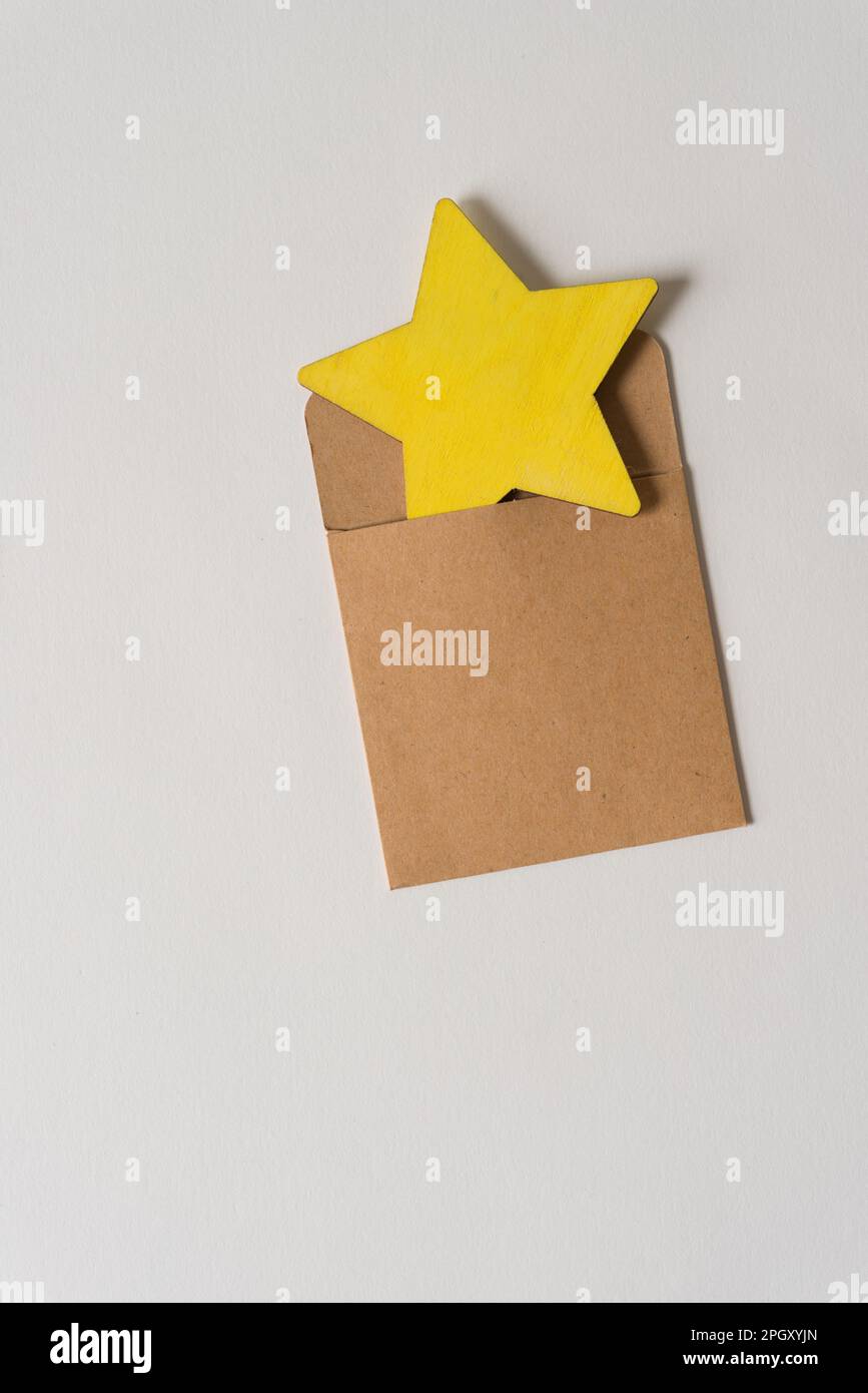 grungy wooden star painted yellow tucked inside a cardboard brown paper ...
