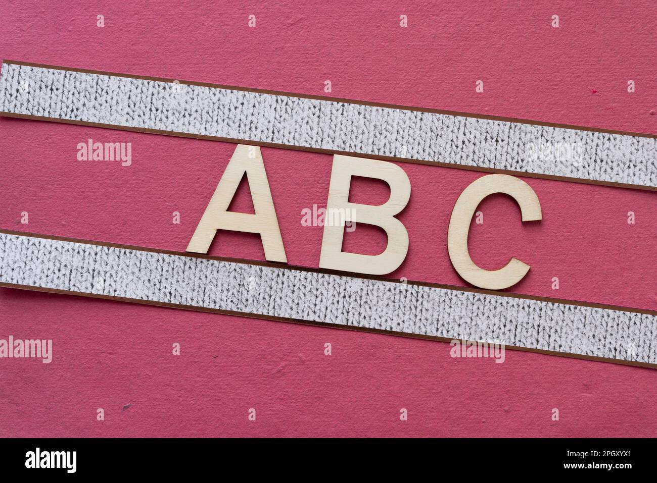 sign with the letters ABC in wood type on rough pink paper Stock Photo ...