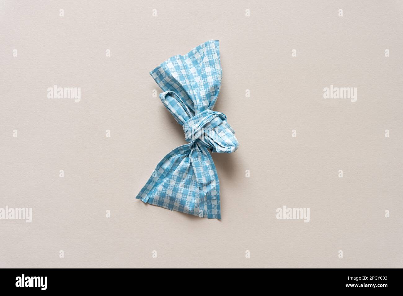 folded ribbon paper vaguely a bow with a tight knot on blank paper ...