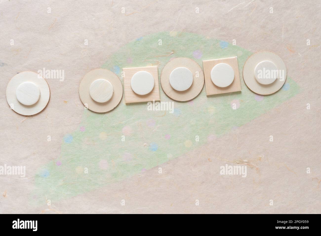 wooden shapes (mostly circles and a couple of squares) on tissue paper ...