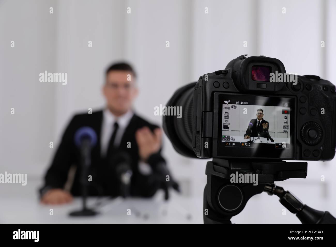 Business man giving interview at official event, focus on video camera ...