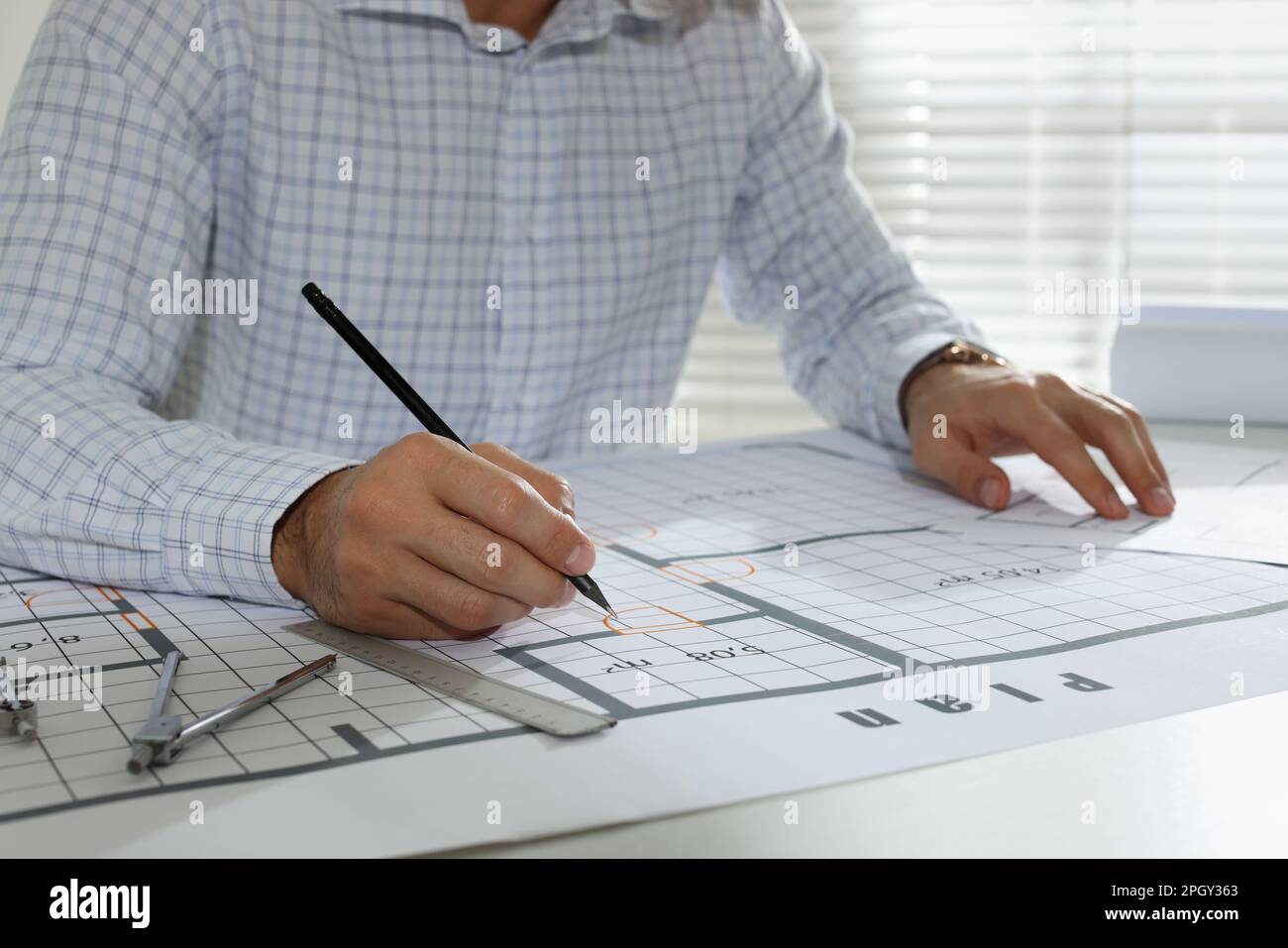 Architect working with construction drawings in office, closeup Stock ...