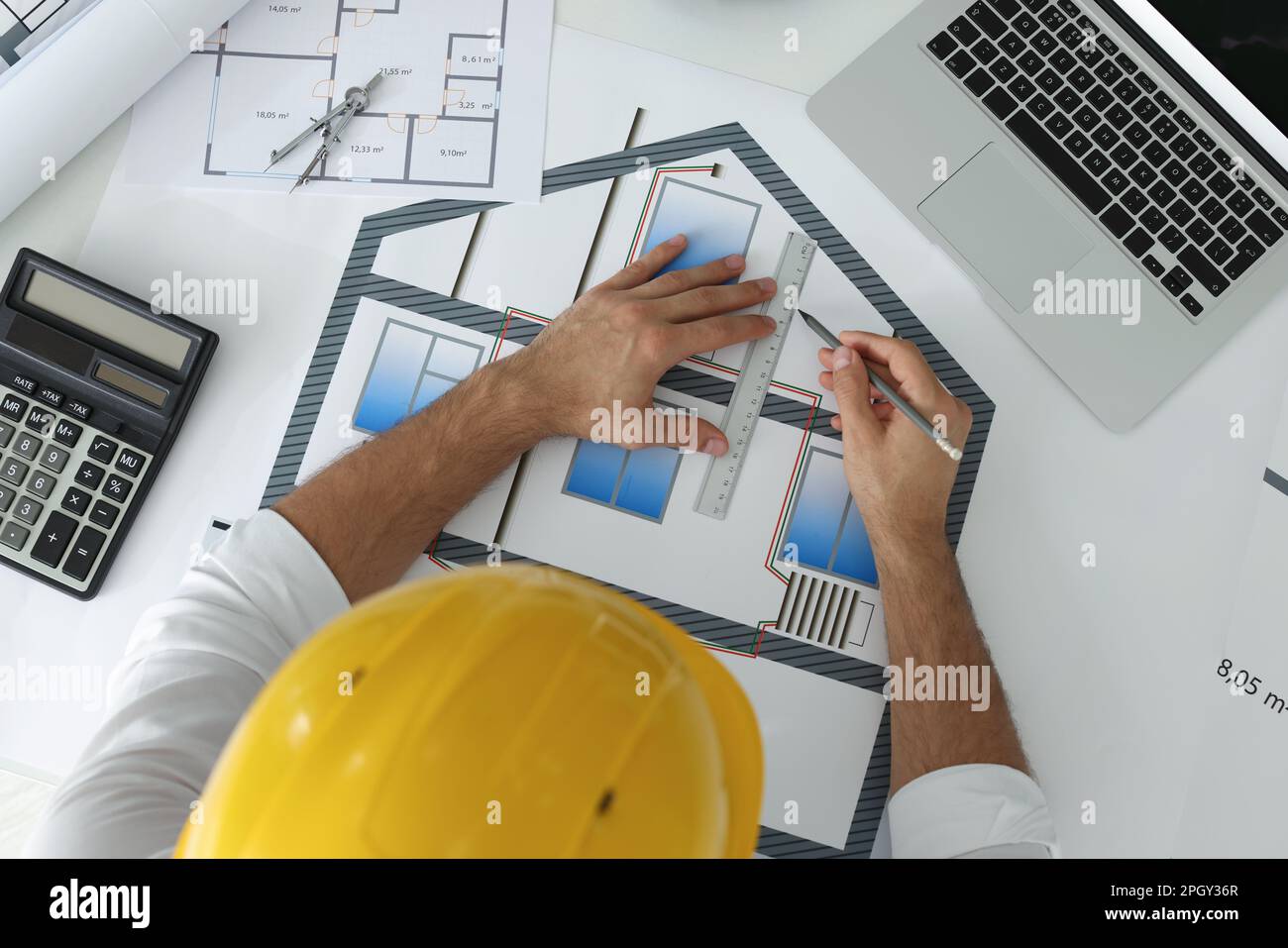 Architect working with construction drawings at white table, top view ...