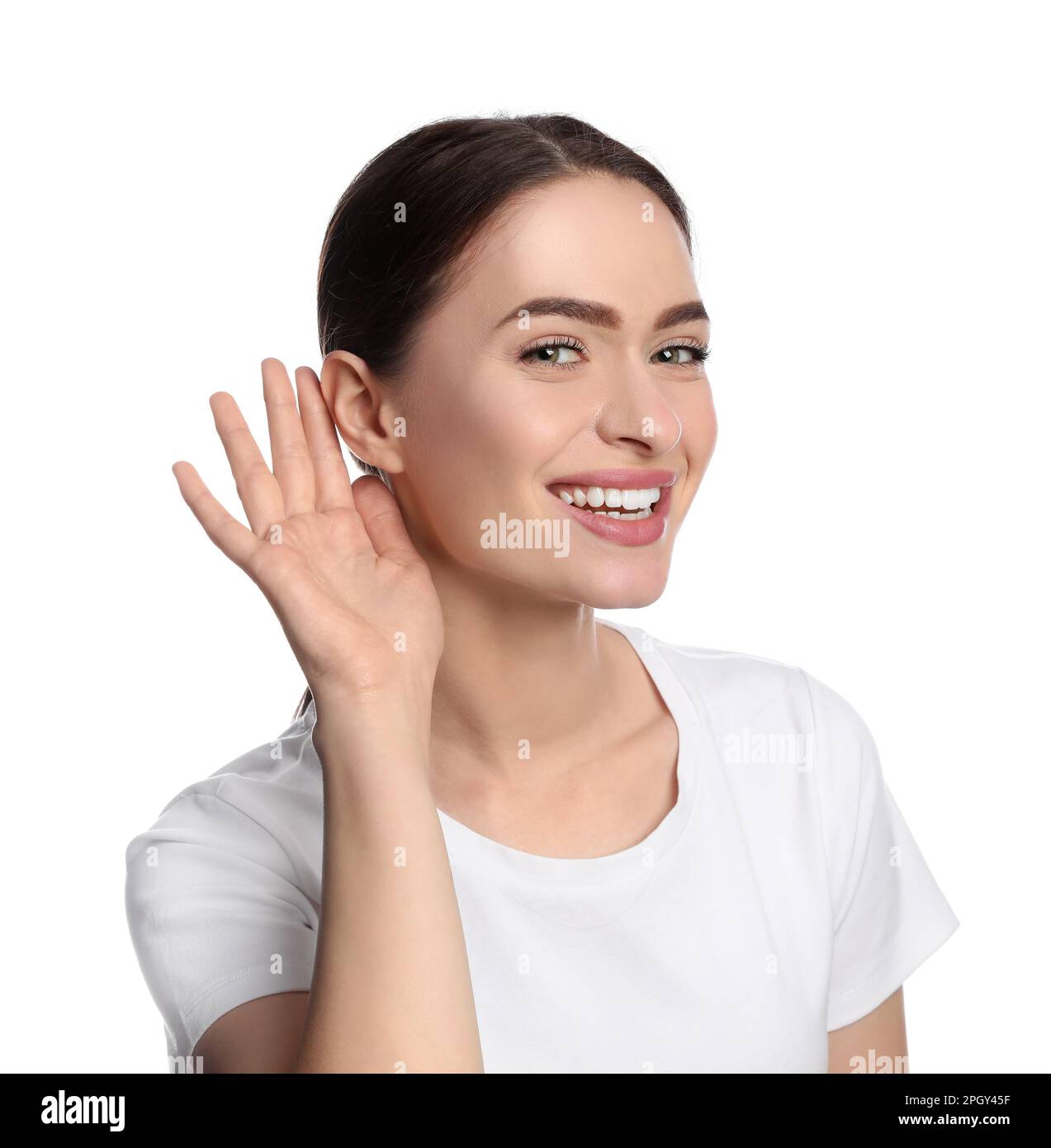Young woman showing hand to ear gesture on white background Stock Photo ...