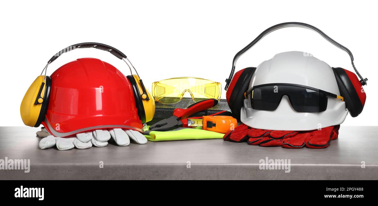 Set with safety equipment and tools on grey stone table against white ...