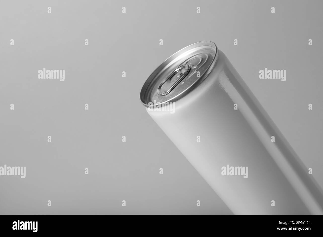 White can of energy drink on light grey background, closeup. Space for ...