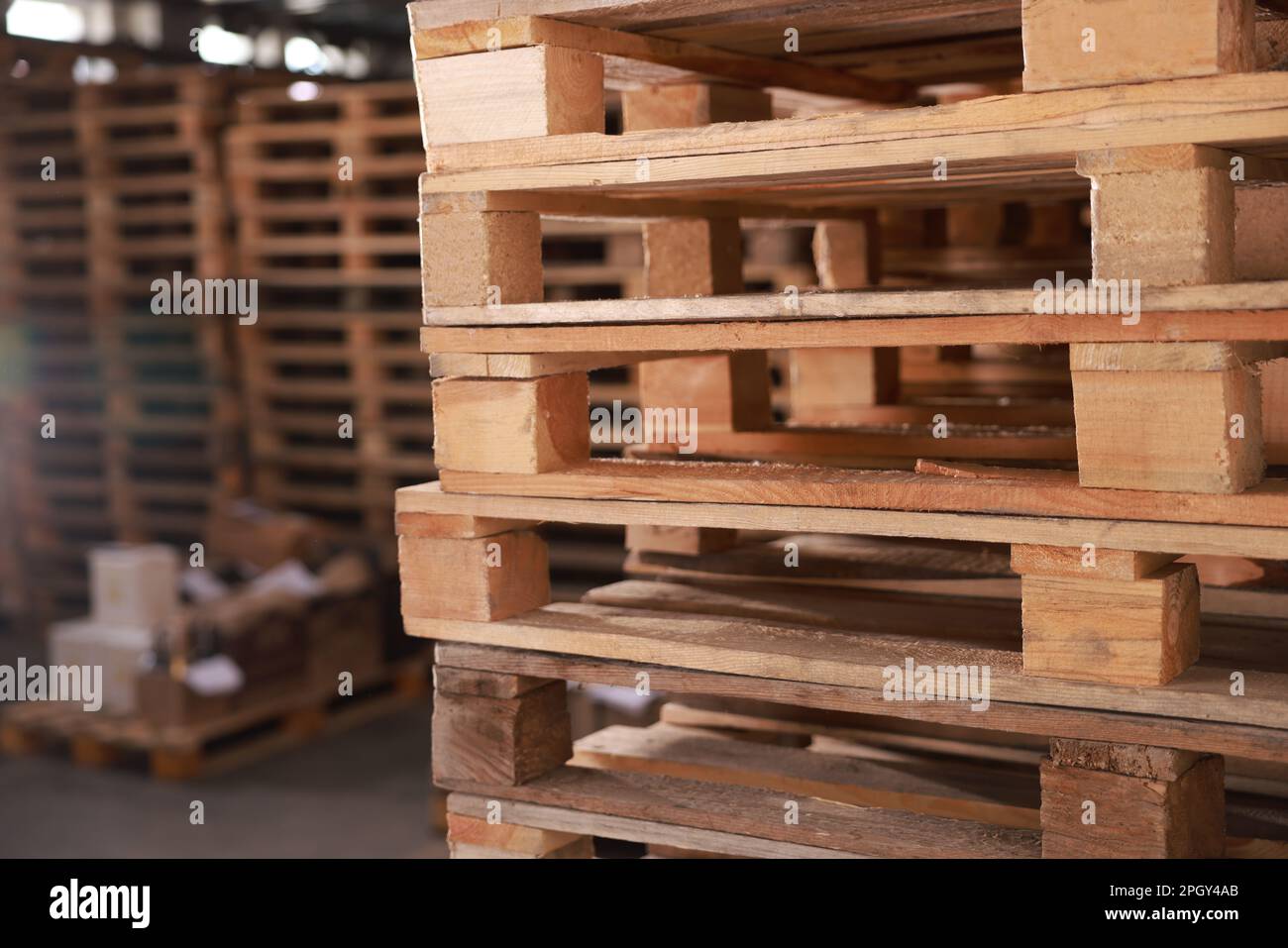 Many empty wooden pallets stacked in warehouse, closeup Stock Photo - Alamy