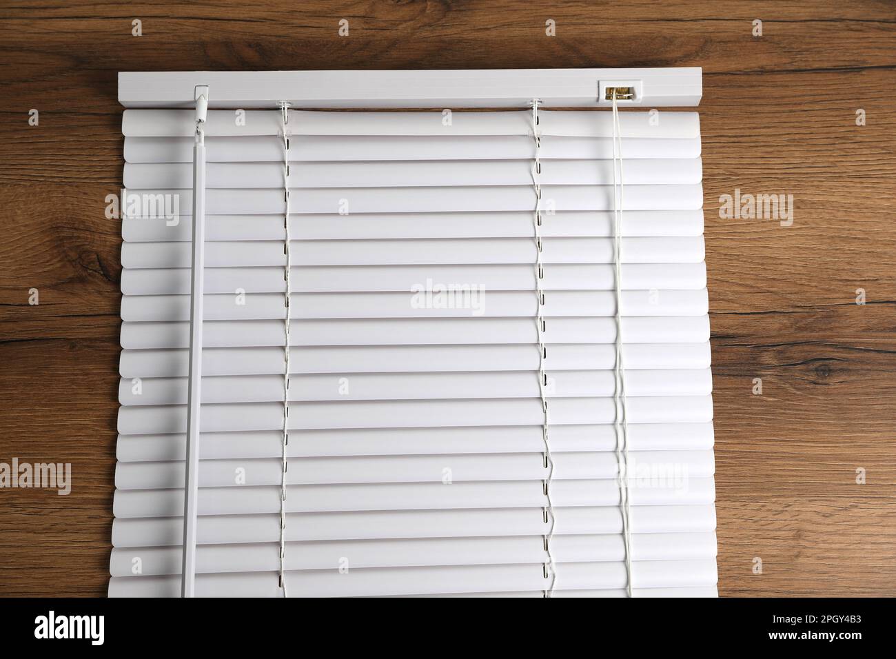 Stylish horizontal window blinds on wooden table, top view Stock Photo ...