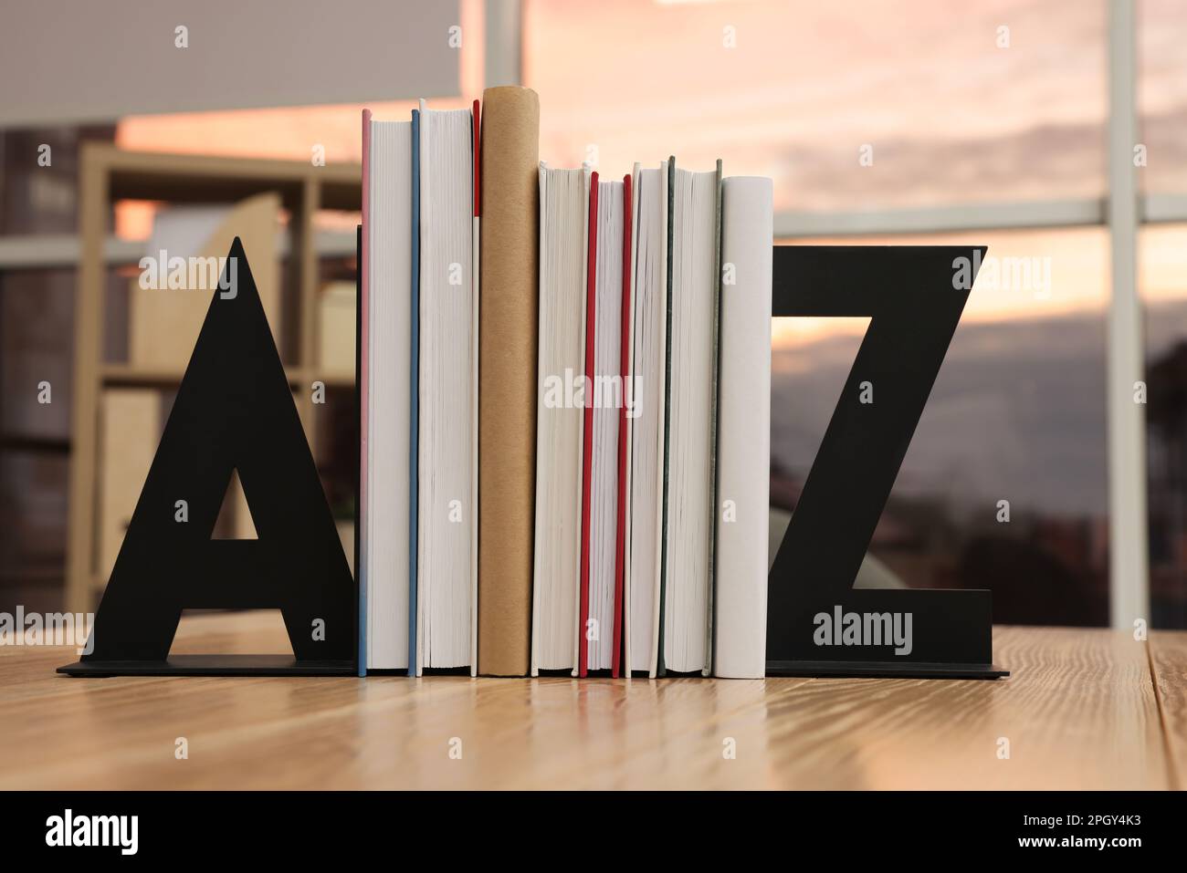 Minimalist letter bookends with books on wooden table indoors Stock ...