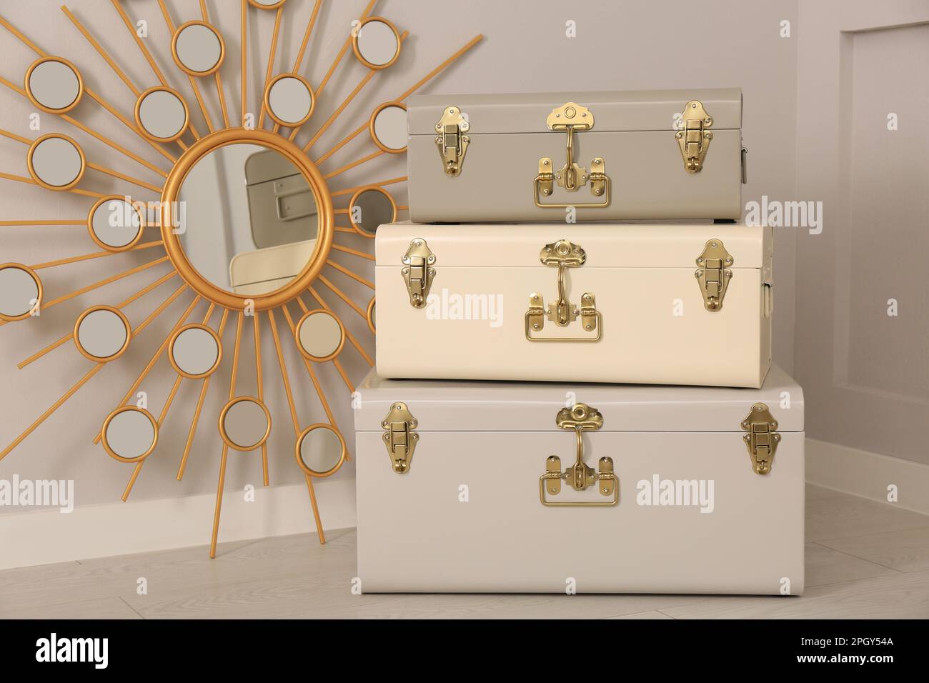 Storage trunks and beautiful mirror near wall indoors. Interior design ...