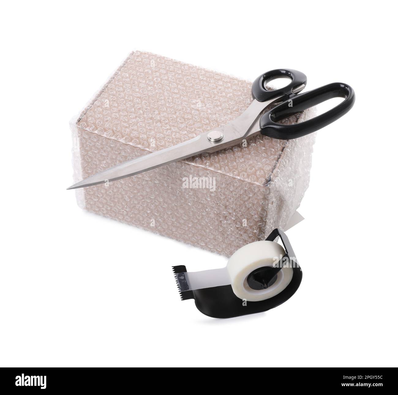 Cardboard box packed in bubble wrap, scissors and adhesive tape on ...