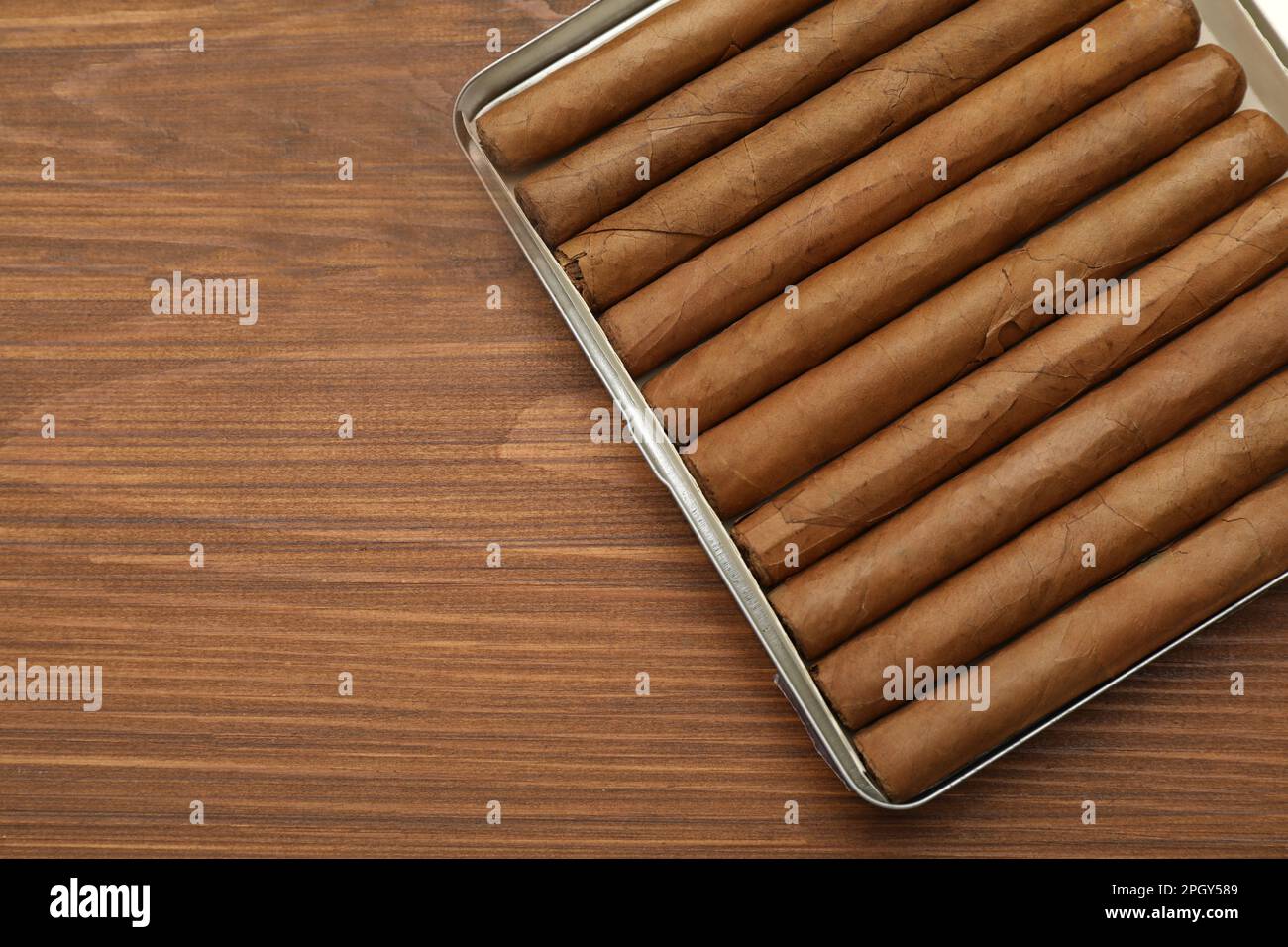 Box with expensive cigars on wooden table, top view. Space for text ...