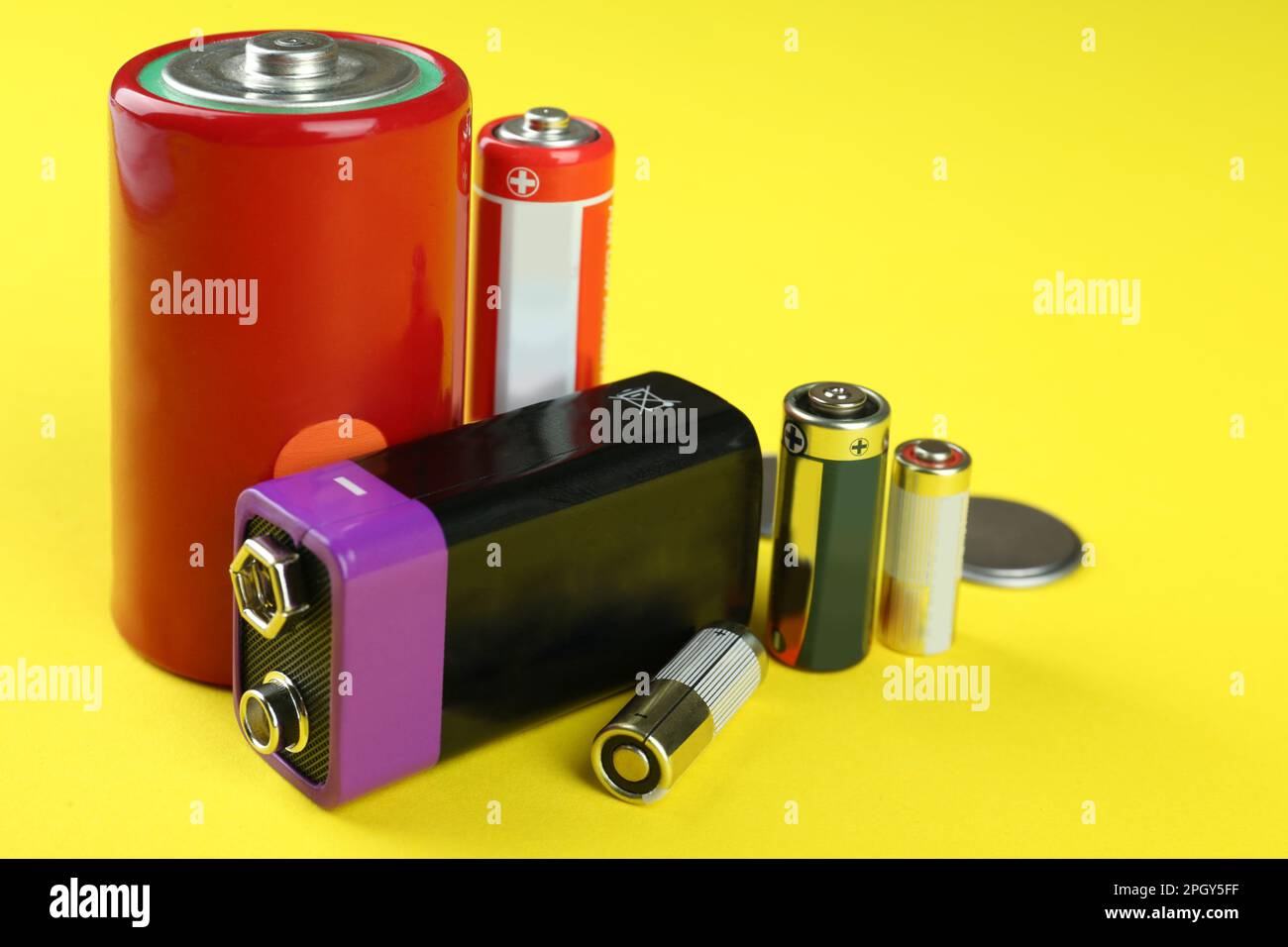 Different types of batteries on yellow background Stock Photo - Alamy