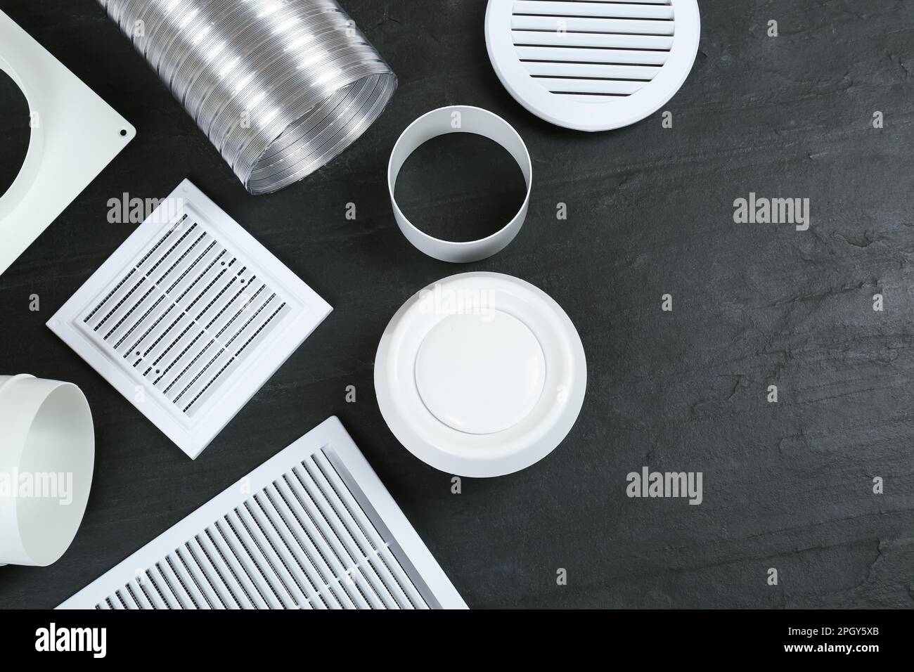 Parts of home ventilation system on black slate surface, flat lay ...