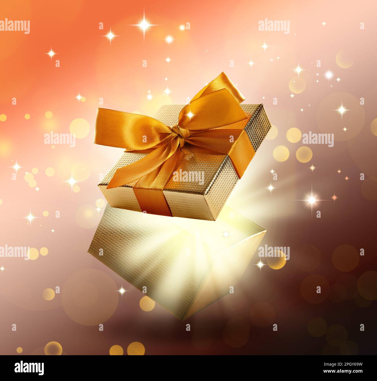 Beautiful gift box with magic light on color background. Bokeh effect ...
