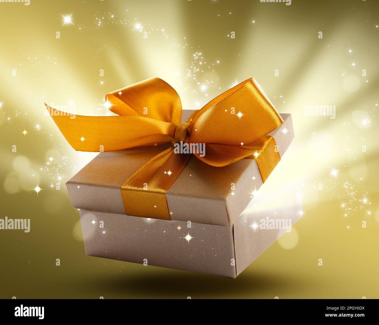 Beautiful gift box with magic light on golden background Stock Photo ...