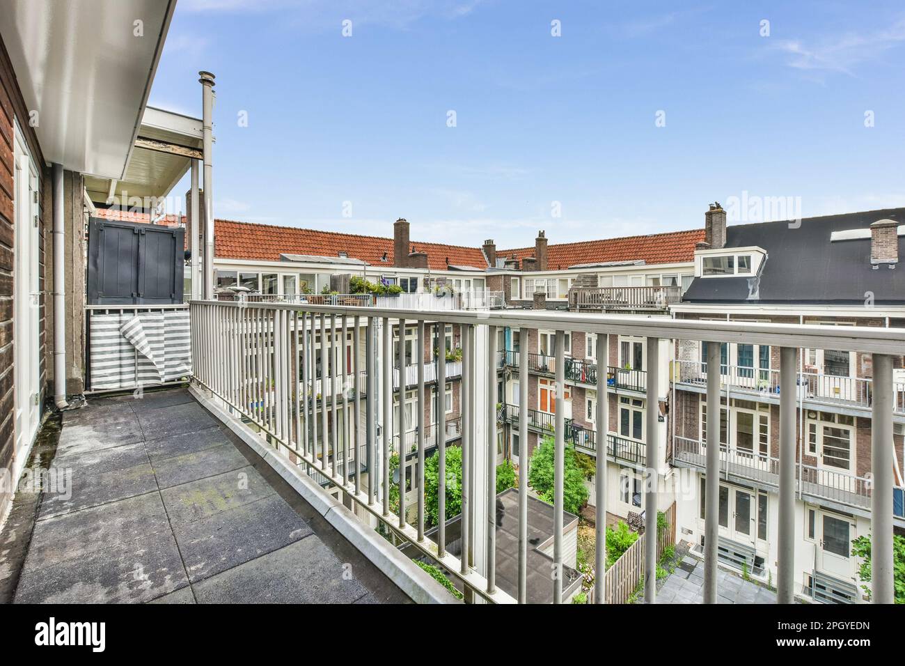 a balcony with some buildings in the background and a blue sky overhead ...