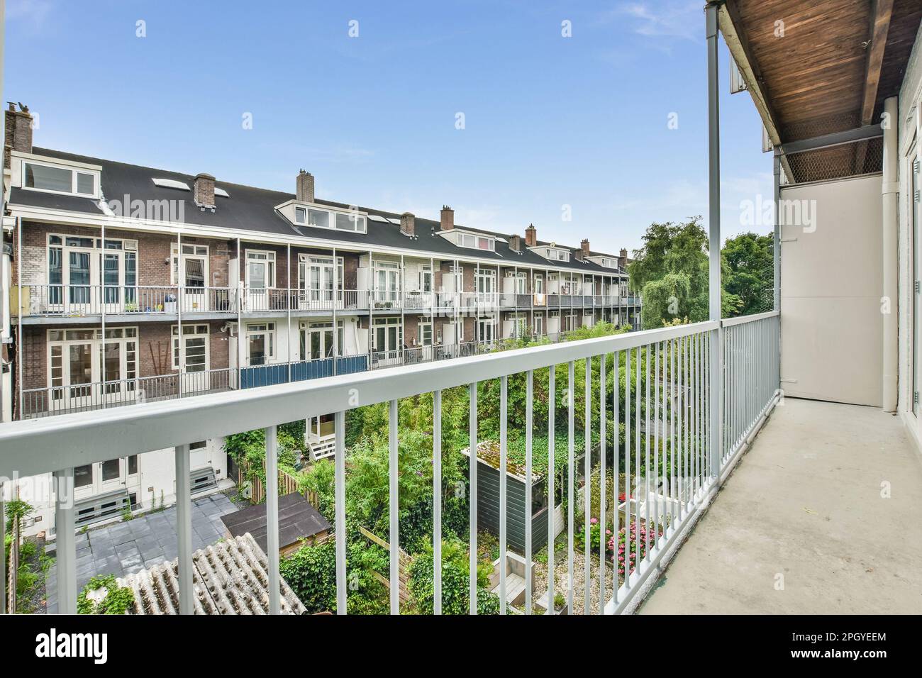 an apartment balcony with white railings and wooden balks on the left ...