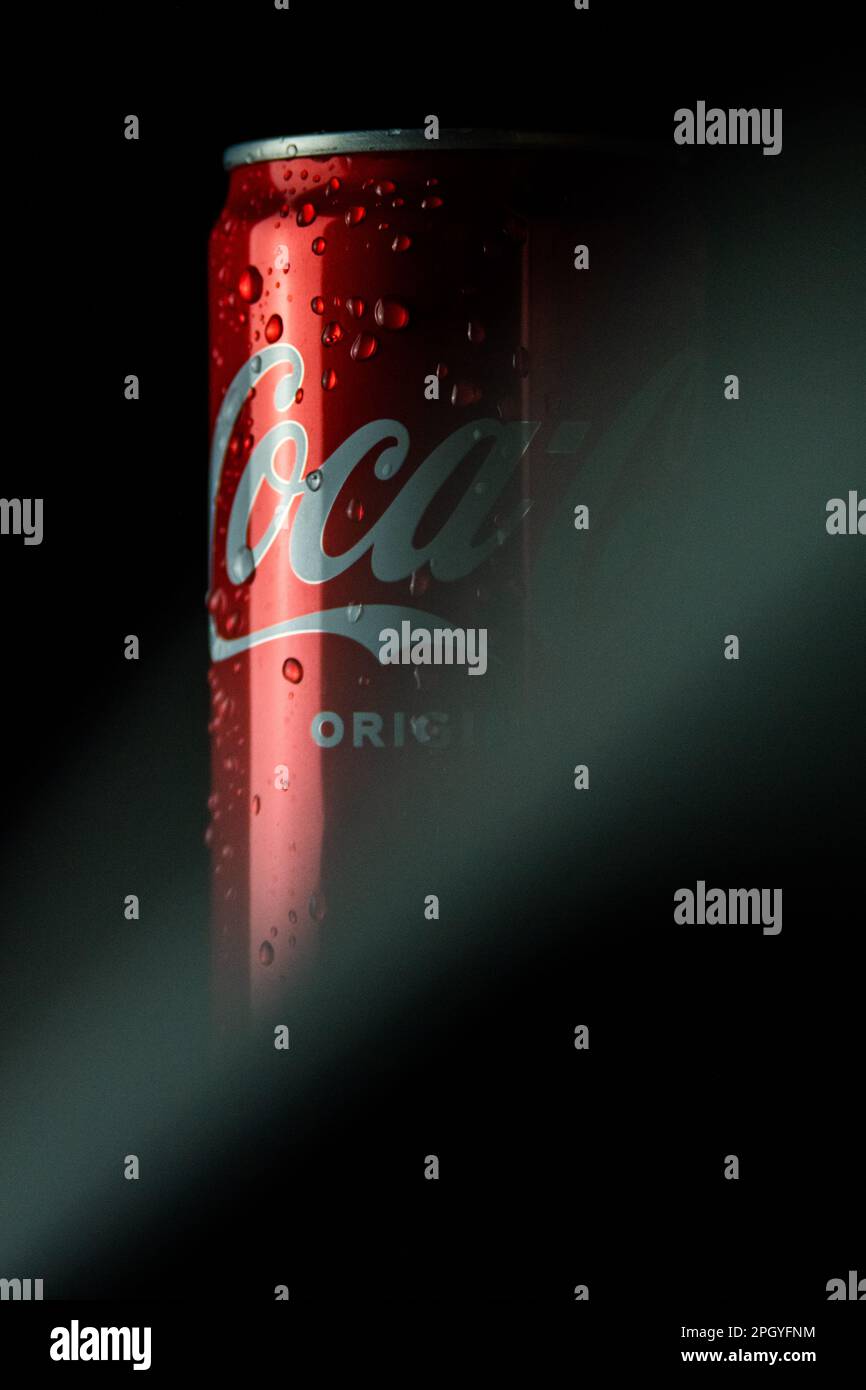 A coke in the middle of a white trail that cuts the can and spreads ...