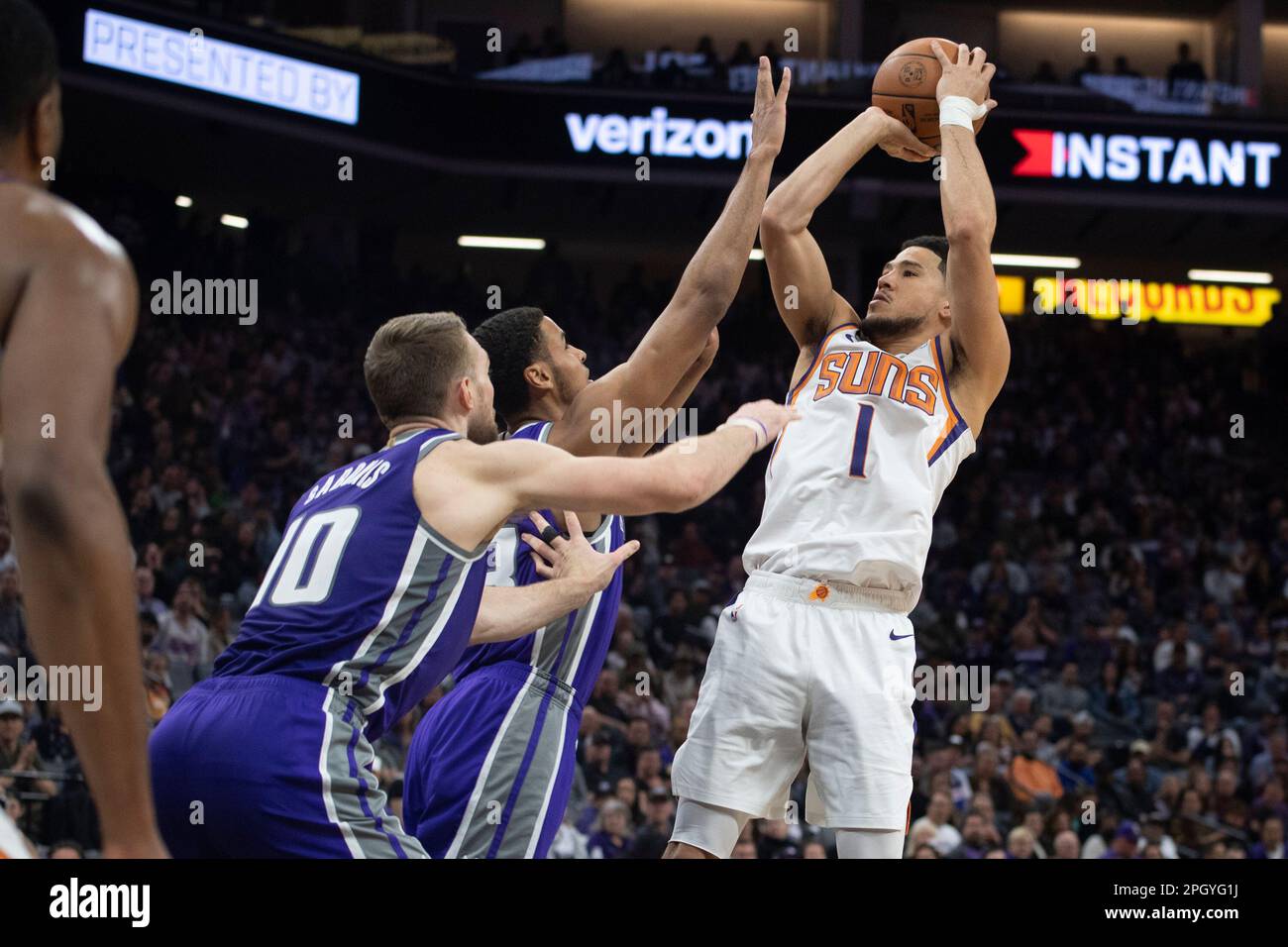 Phoenix Suns guard Devin Booker (1) shoots over Sacramento Kings forward Keegan Murray, center ...