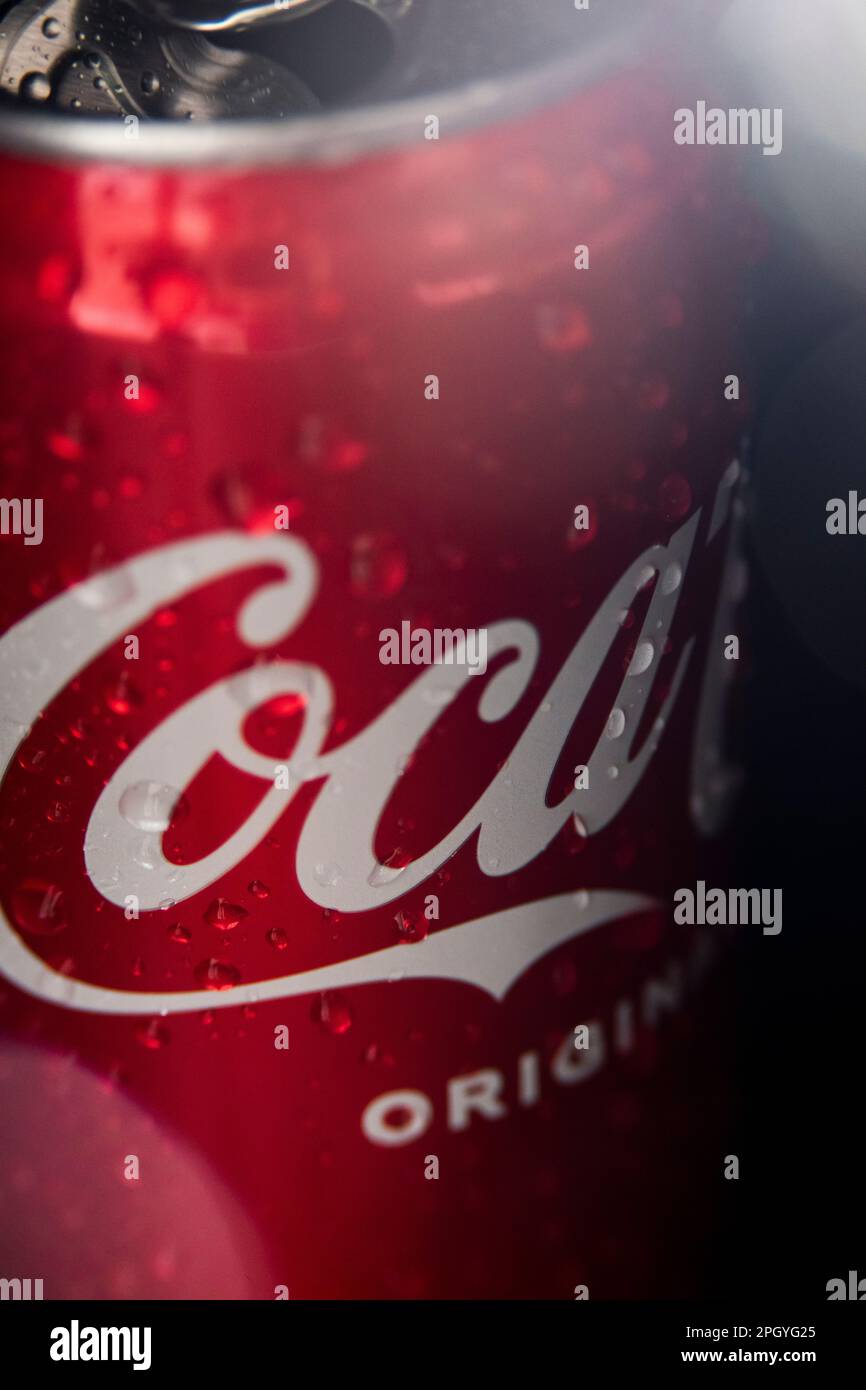 A diffused light penetrates the Coca-Cola brand among drops of ...