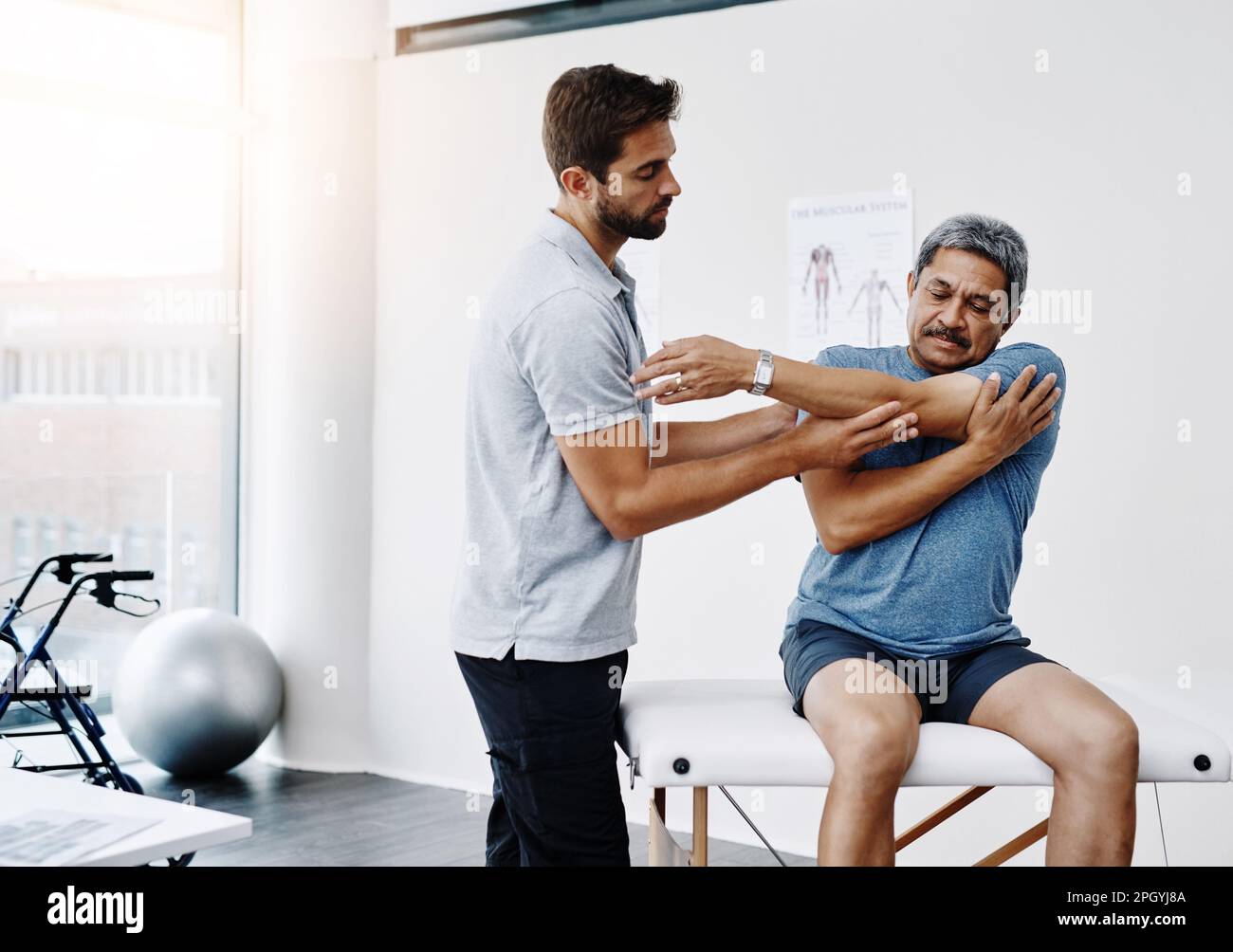You did well today. a young male physiotherapist helping a mature male ...