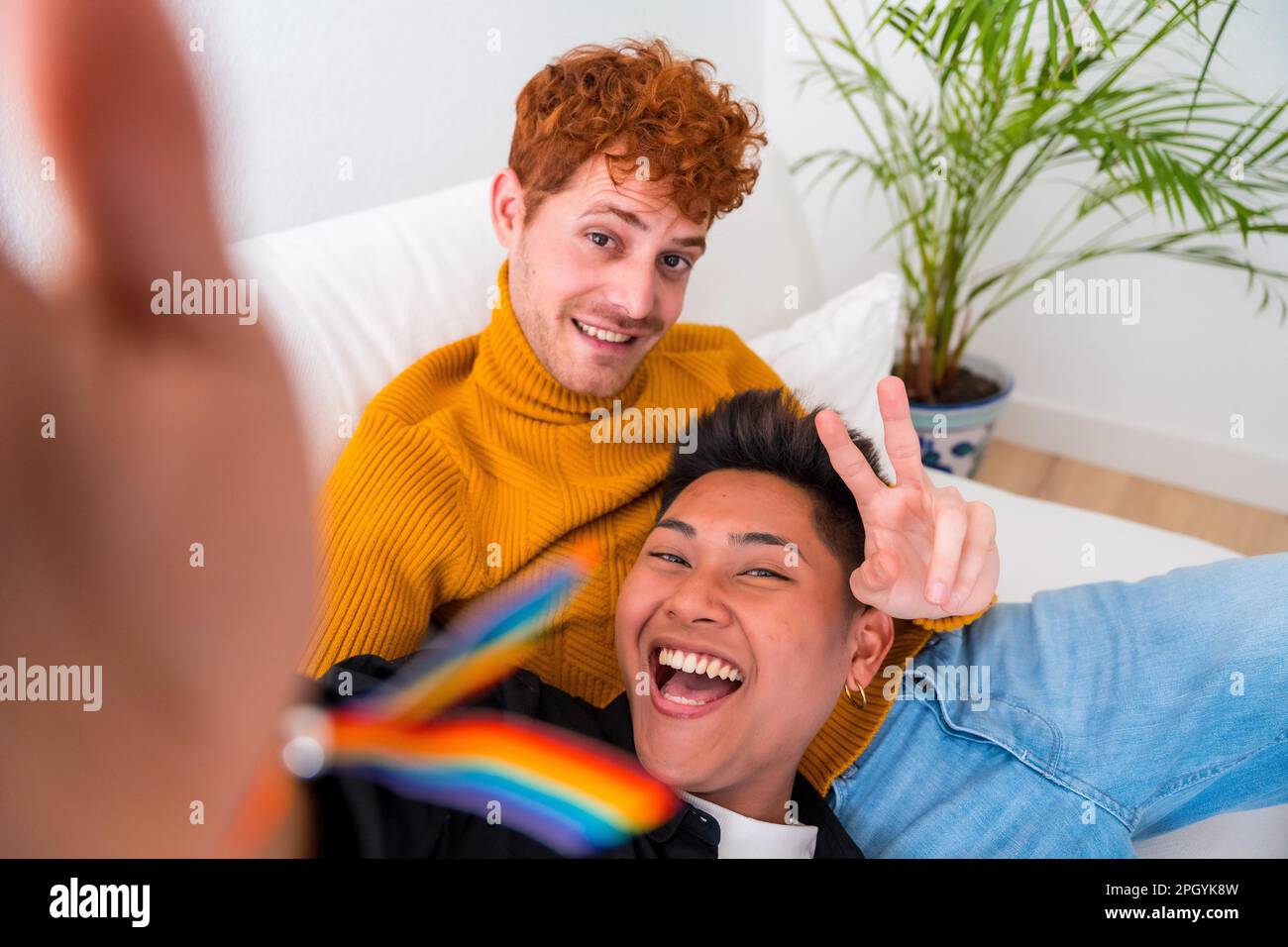 Beautiful Gay Couple Being Romantic Indoors At Home On The Sofa Gay Couple Taking Selfie And