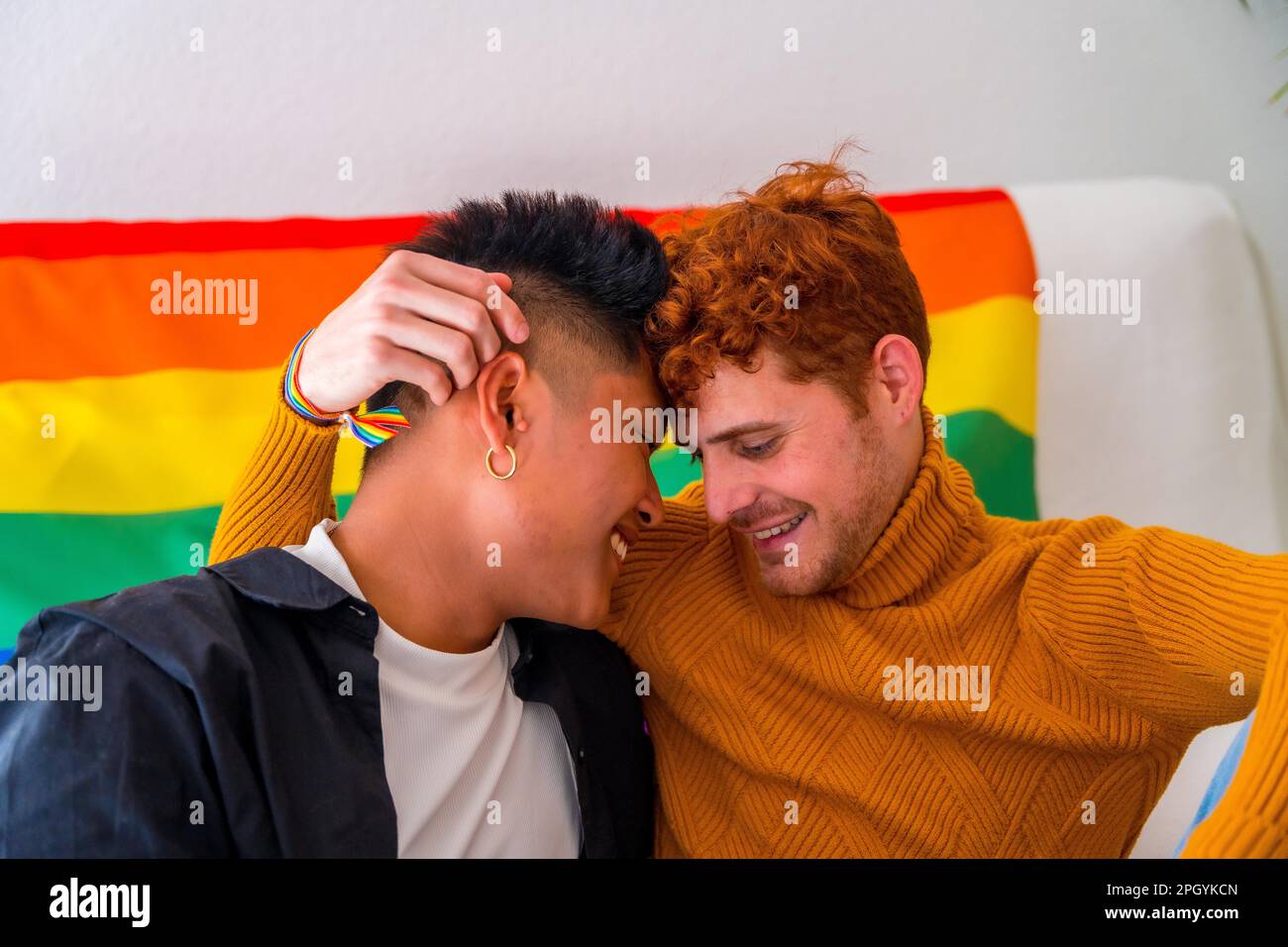 Beautiful gay couple being romantic at home by the sofa, lgbt concept ...