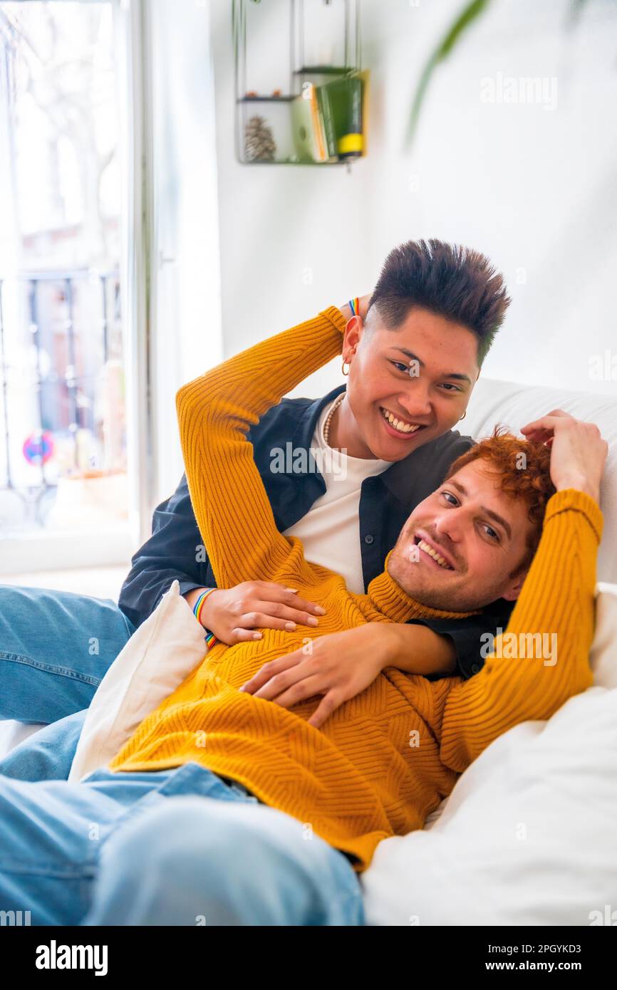 Beautiful Gay Couple Being Romantic At Home On The Sofa Portrait