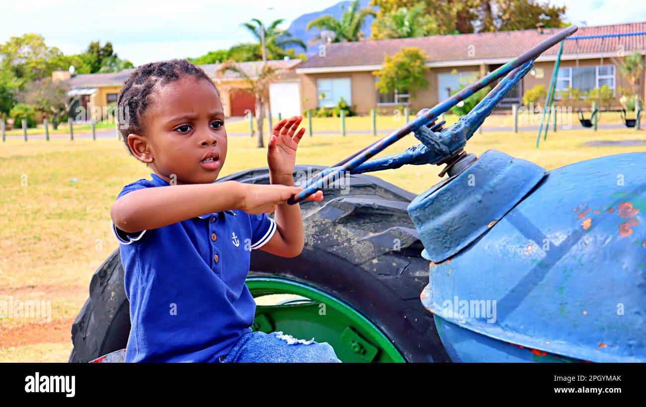 African black young boy play on a tractor in a park Stock Photo - Alamy