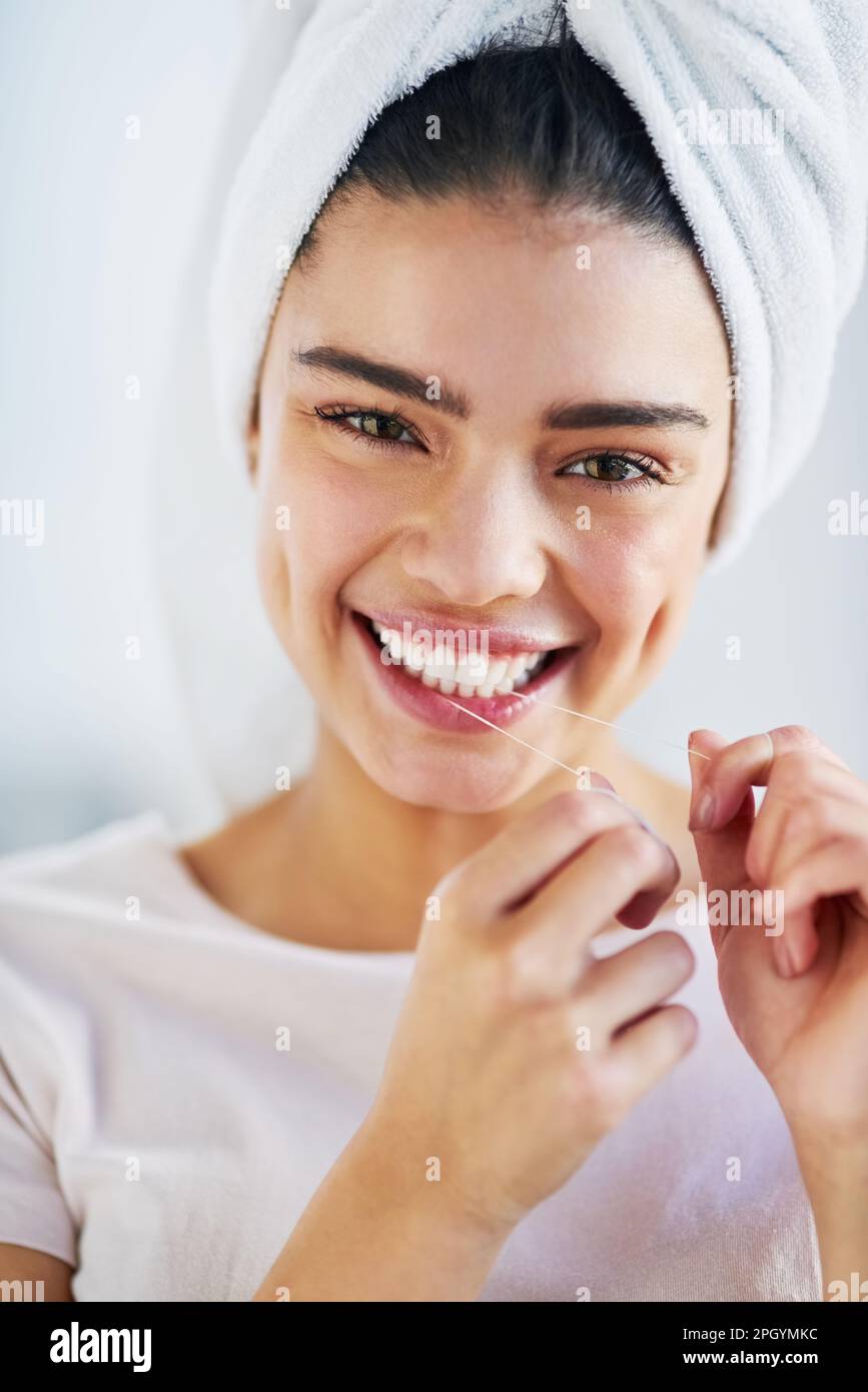 Floss as much as you brush. Portrait of a beautiful young woman ...