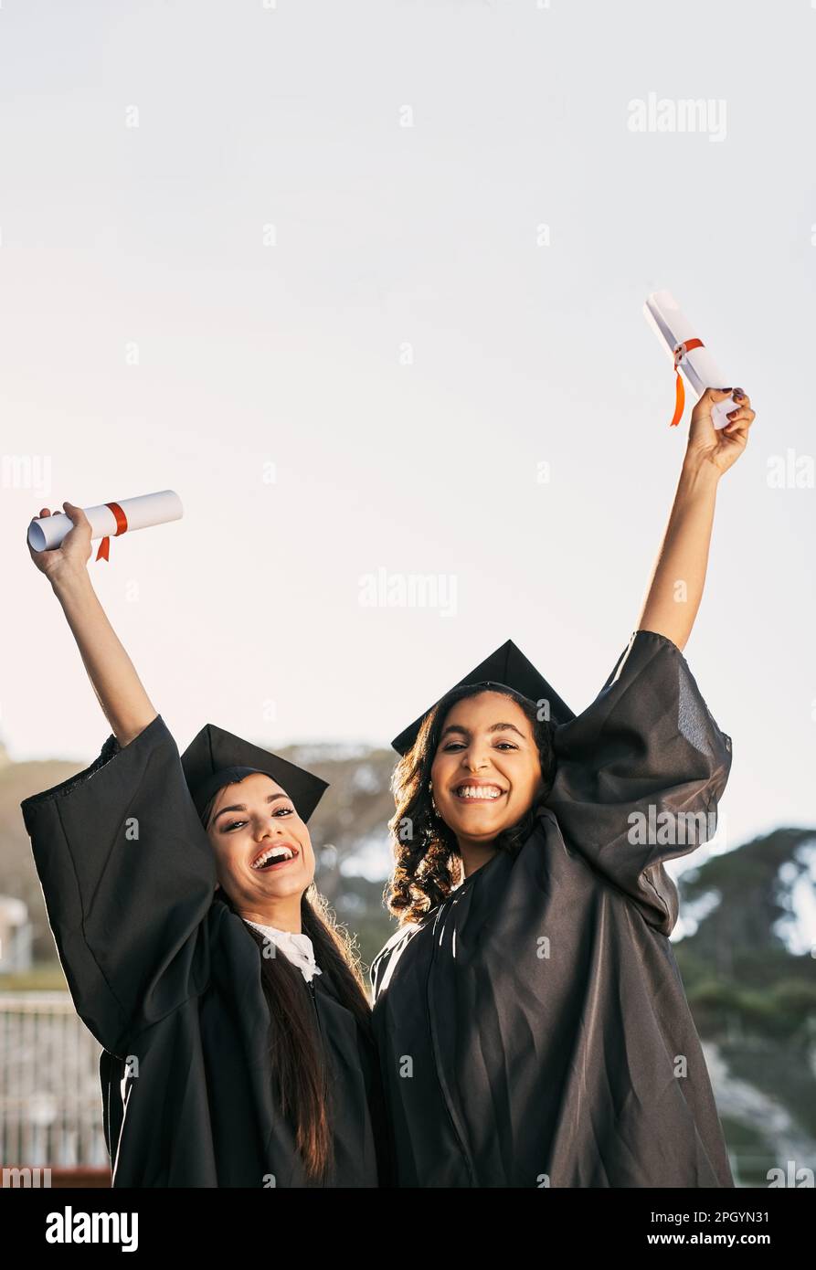 Dream big, achieve bigger. Portrait of two students celebrating with ...