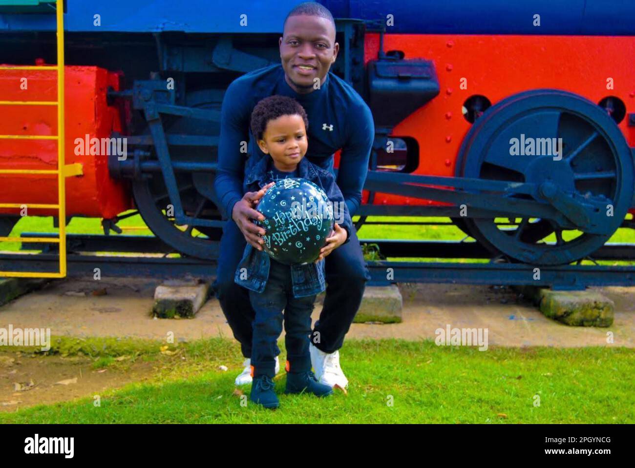 African father playing with his son in a park Stock Photo - Alamy